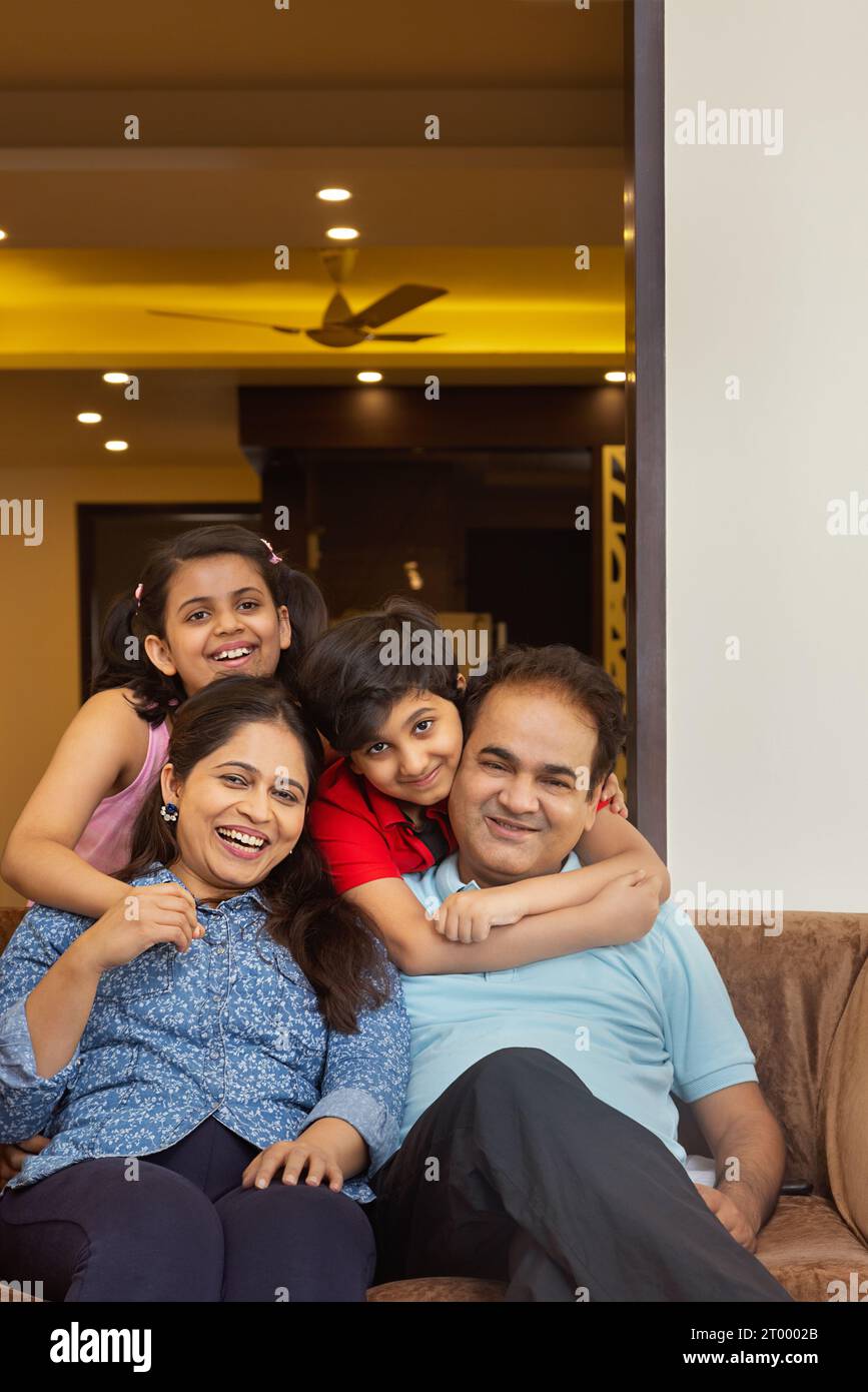 Portrait of happy middle class family enjoying together in living room ...