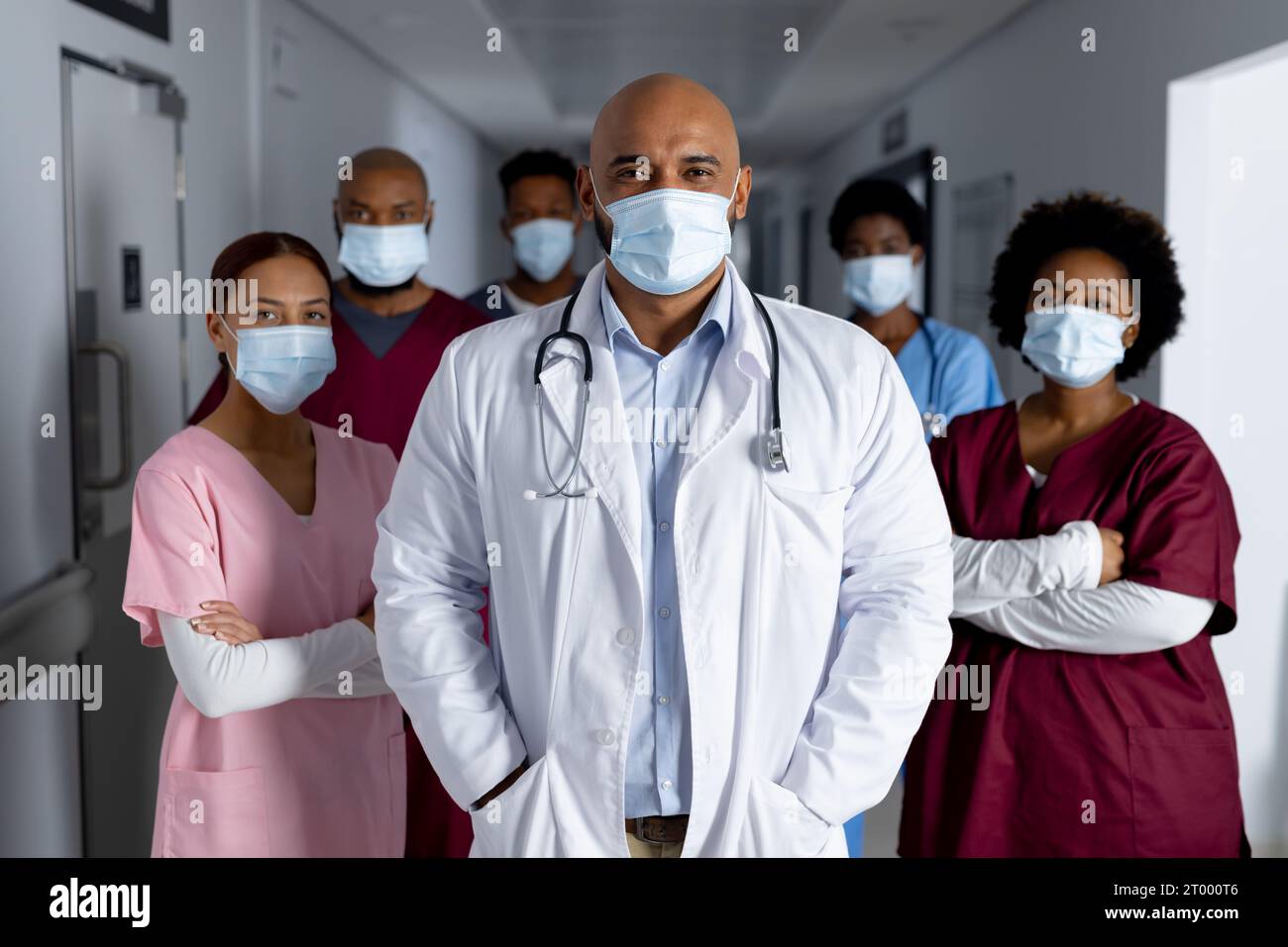 Portrait of diverse doctors wearing face masks in corridor at hospital ...