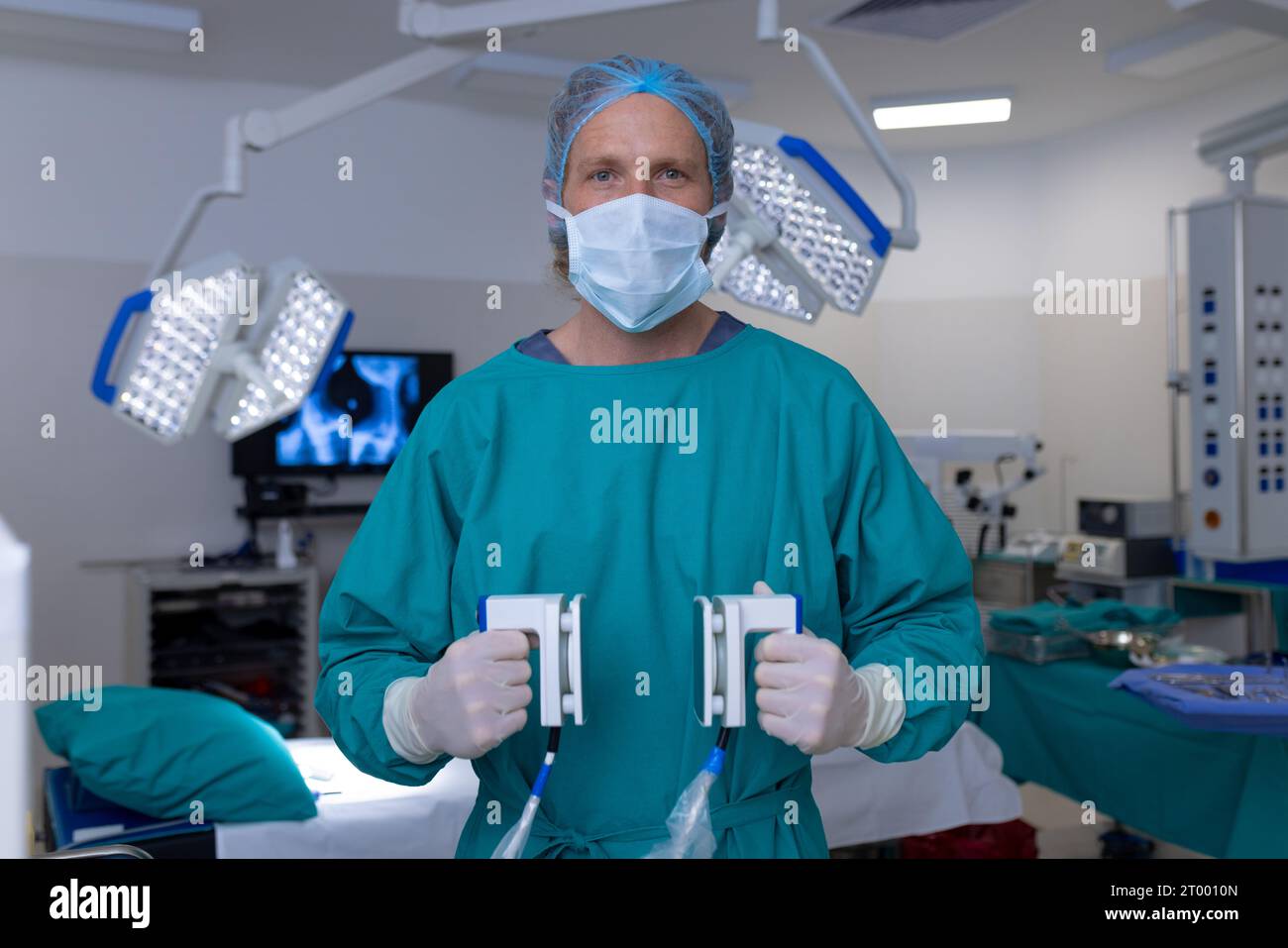 Portrait of caucasian male surgeon wearing surgical gown in operating ...