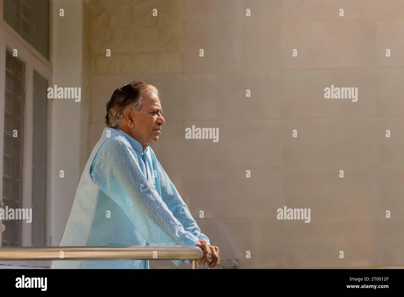 Portrait of senior man standing alone in balcony Stock Photo - Alamy