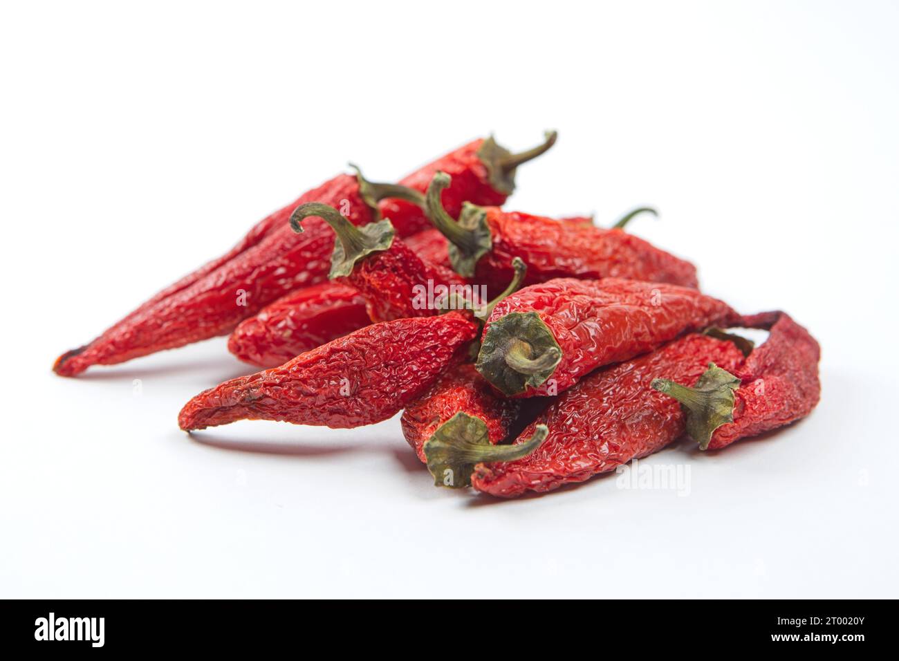 Wrinkled red peppers on white background Stock Photo - Alamy