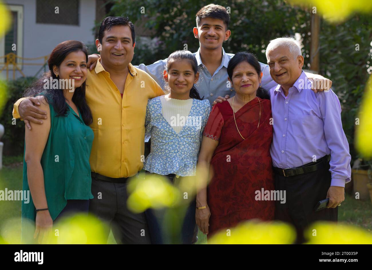 Multi generation happy Indian family standing together in backyard ...