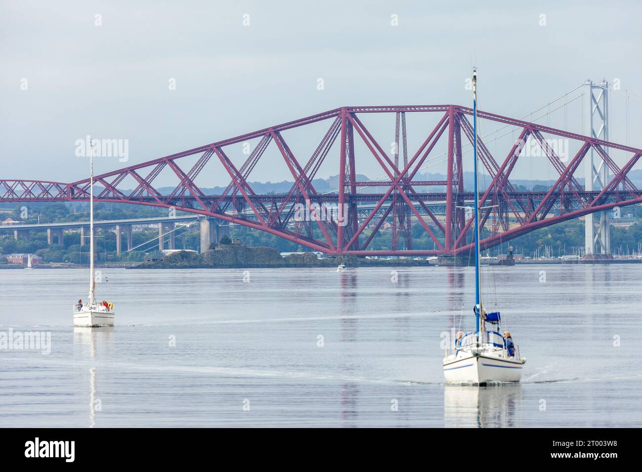 Two yachts sailing up the Firth of Forth with the Forth Bridge in the ...