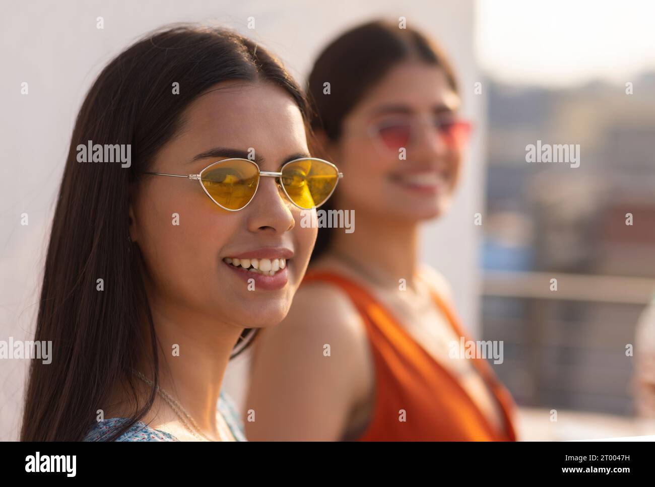 Close-up portrait of two young women standing in balcony of a tourist ...