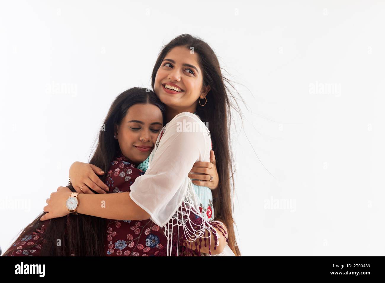 Portrait of two female friends embracing against white background Stock ...