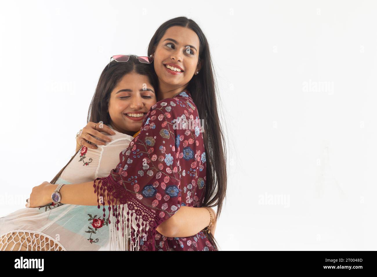 Portrait of two female friends embracing against white background Stock ...