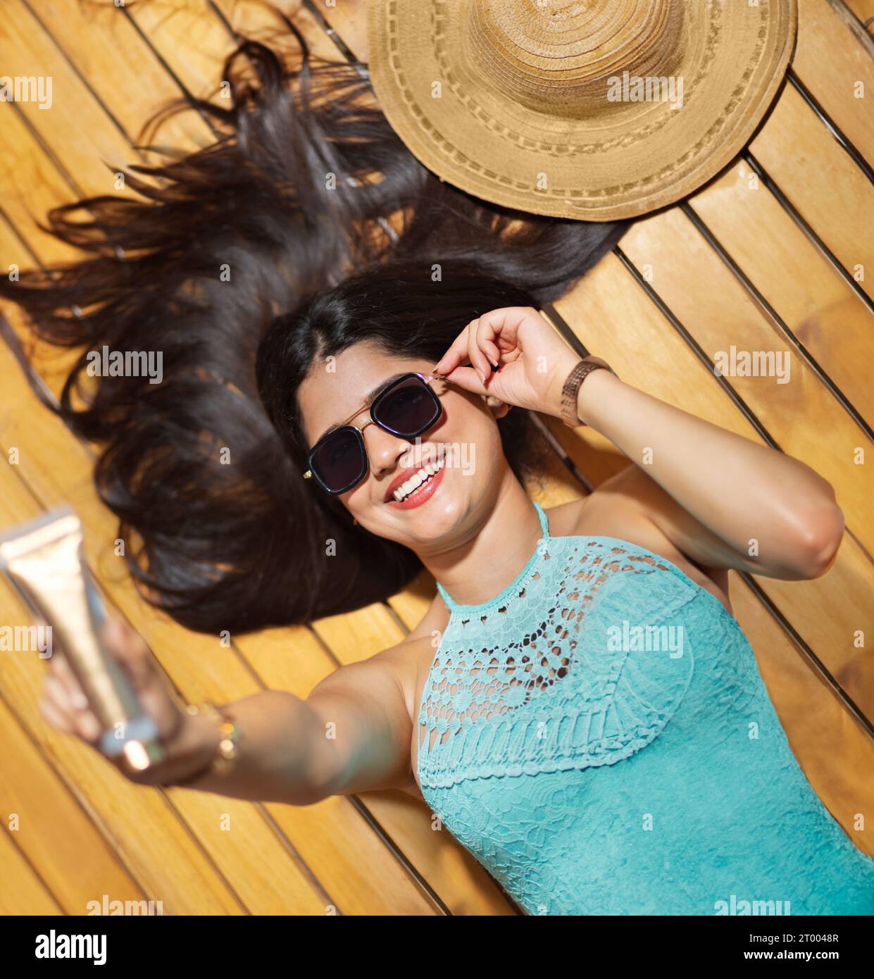 Woman sunbathing on sun lounger by swimming pool Stock Photo - Alamy