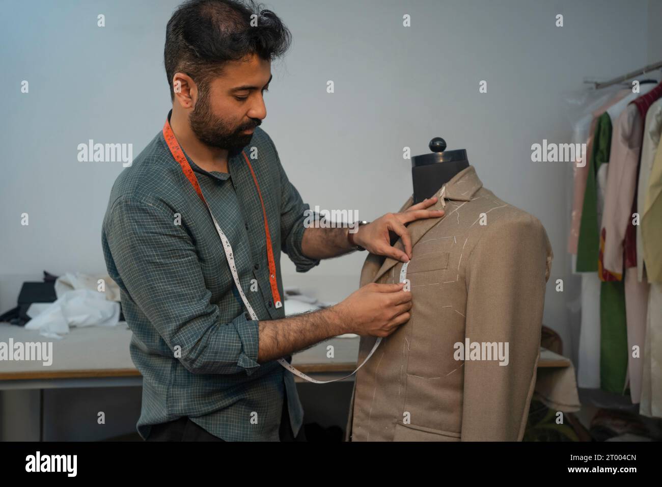 menswear designer working on a bespoke jacket in his studio Stock Photo ...