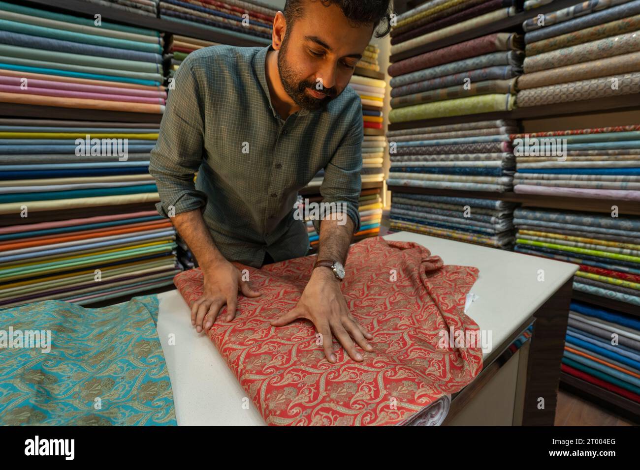 Man showing a piece of patterned fabric in a clothing store Stock Photo ...