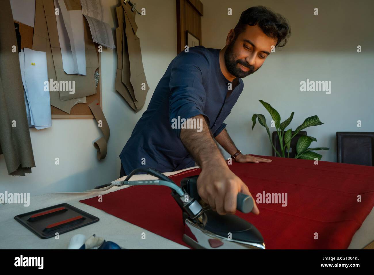 A male fashion designer ironing fabrics in his studio Stock Photo - Alamy