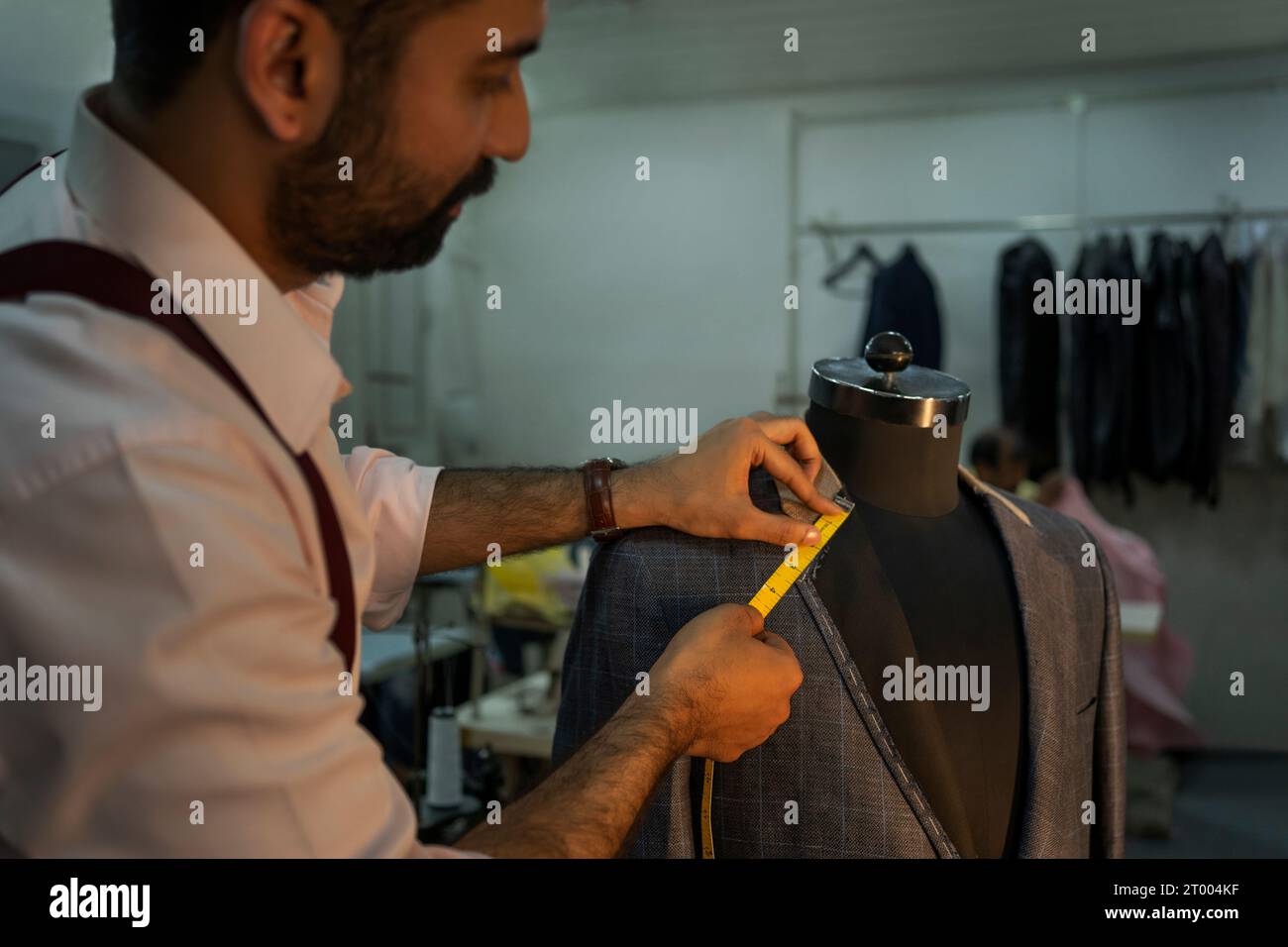 A bespoke tailor checking measurements on a dress form Stock Photo - Alamy