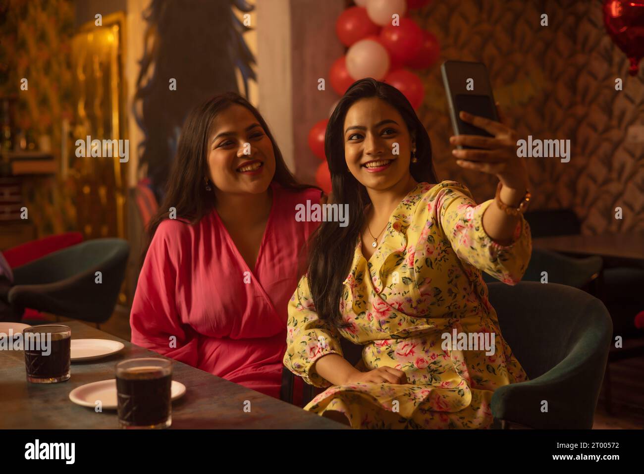 Women taking selfie while sitting together at restaurant Stock Photo ...