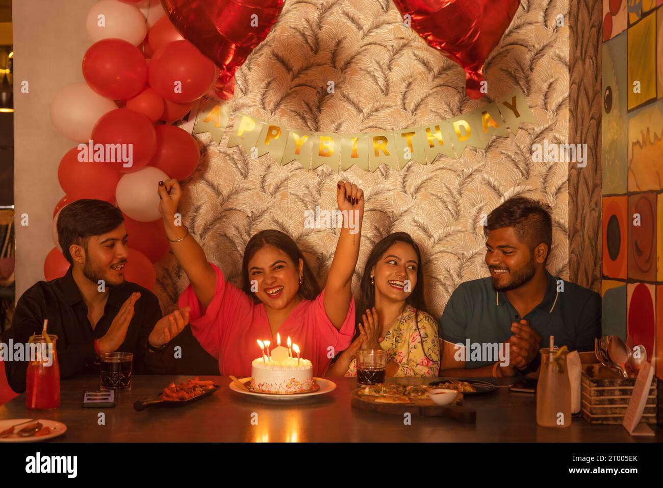 Friends celebrating birthday of their friend at restaurant Stock Photo ...