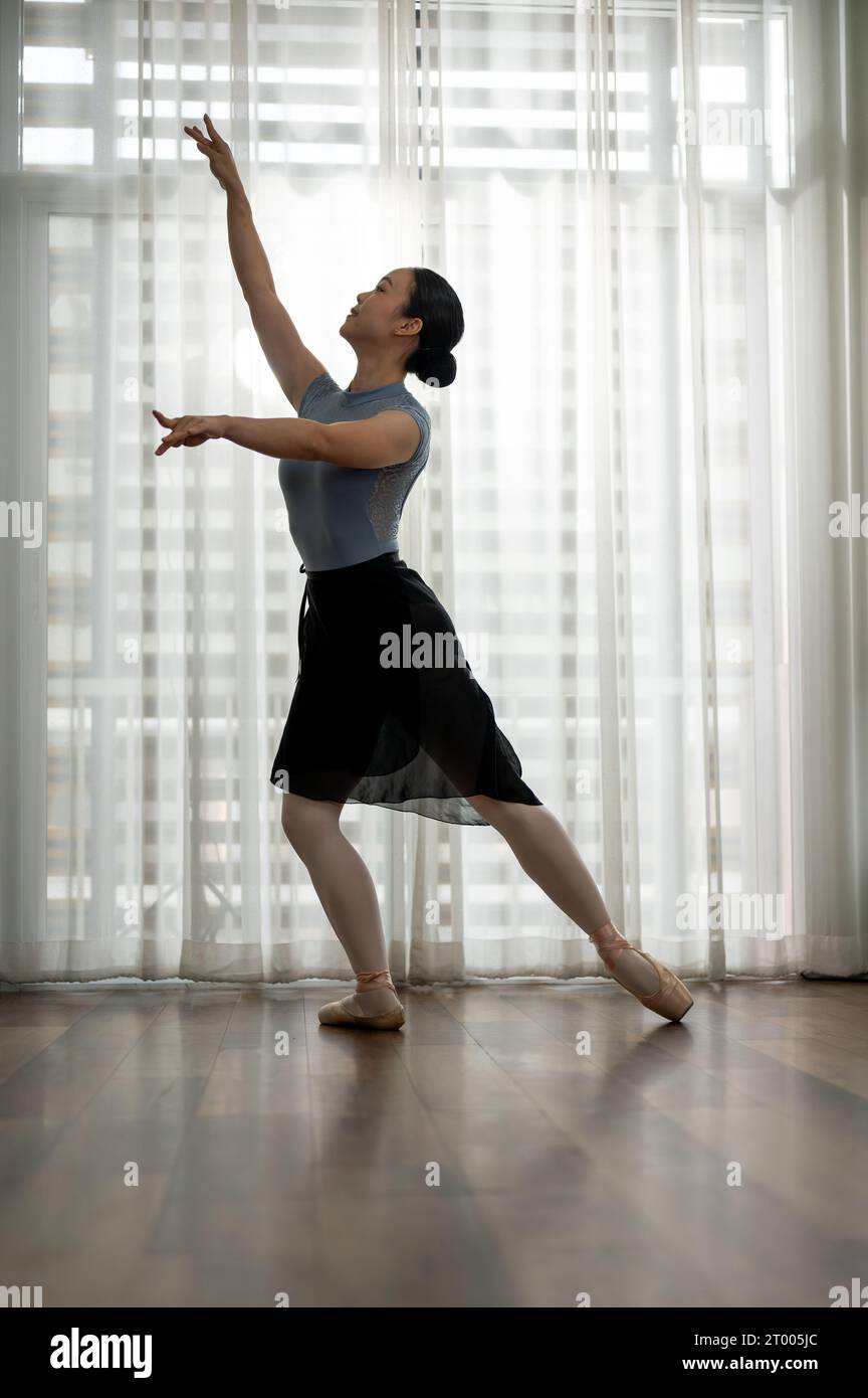 Beautiful woman performing a ballet dance, practicing her dance move at ...