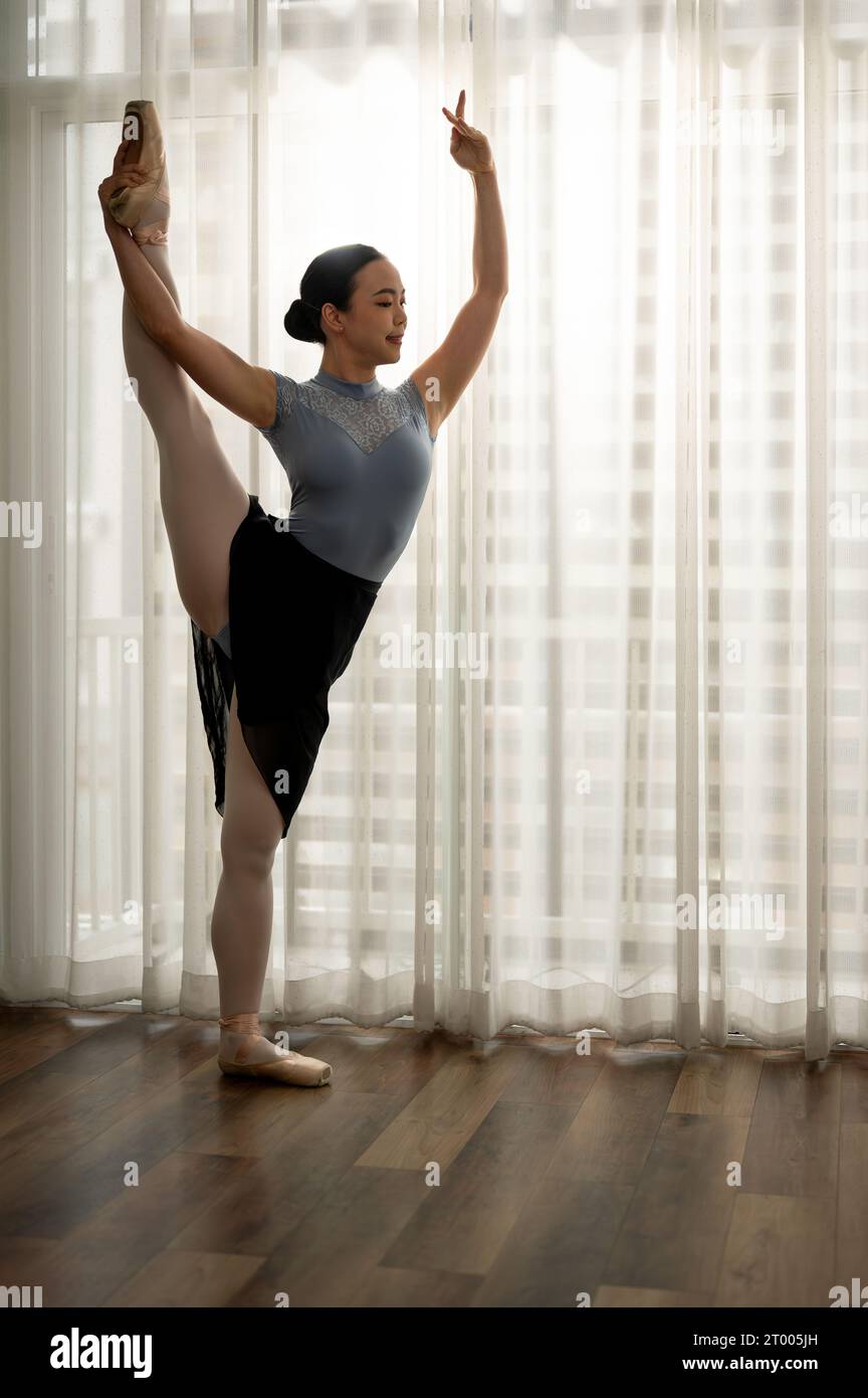 Young ballerina dancing and practicing her movement at home before the ...