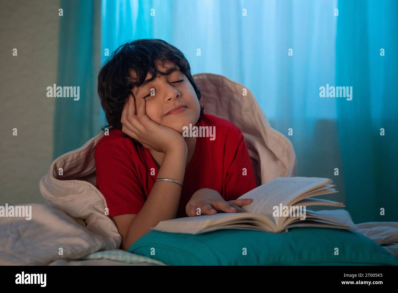 Boy thinking while reading a book on bed Stock Photo - Alamy