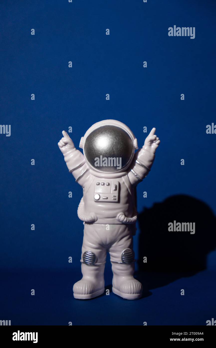 Plastic toy astronaut on colorful blue background Copy space. Concept ...