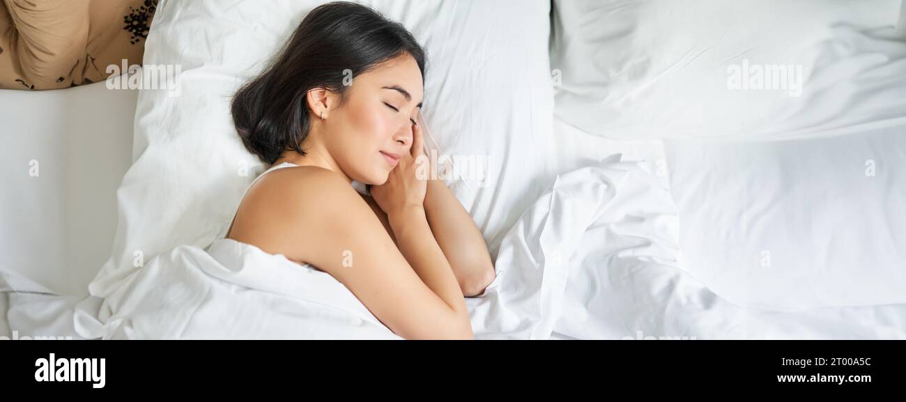 Top view image of asian woman sleeping alone in king size bed on white ...