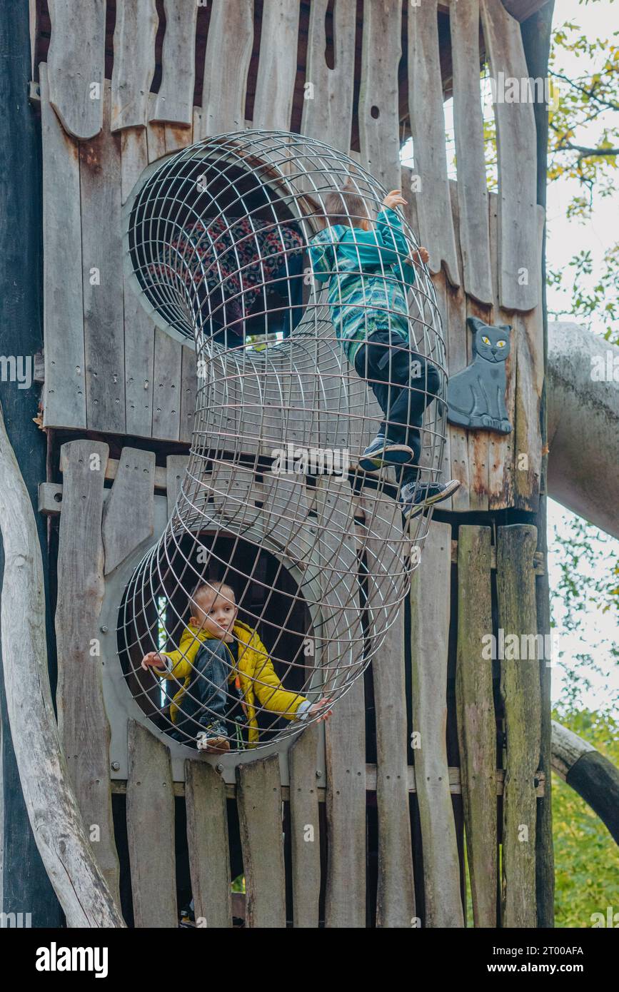 A child climbs up an alpine grid in a park on a playground on a hot ...