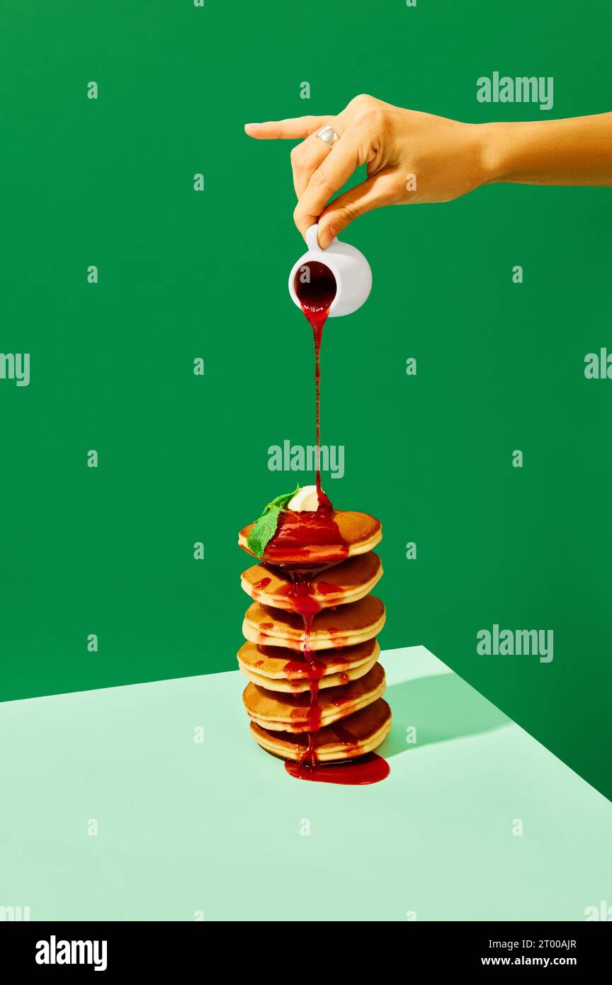 Food pop art photography. Close up. Female hand pouring sweet jam on ...