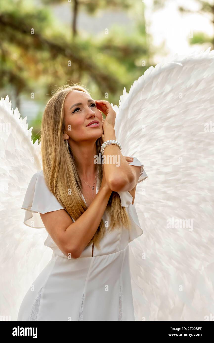 A Lovely Blonde Model Poses Outdoors While Wearing White Handmade Wings ...
