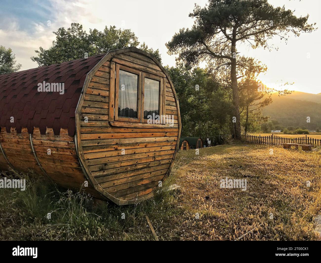A wooden barrel house with an impressively tall stature in a vast field ...