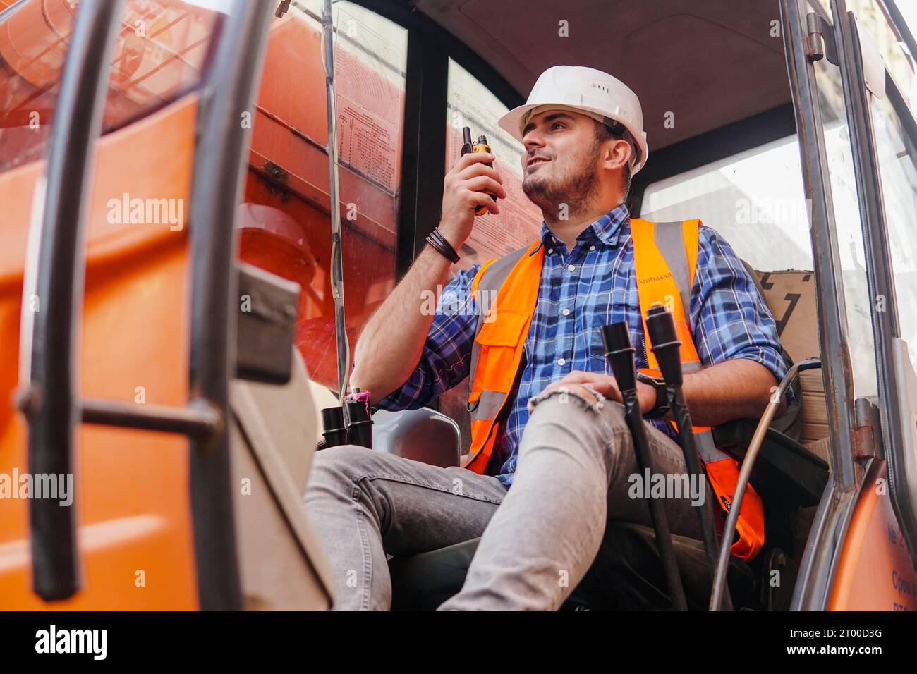 Young man loader worker or a forklift driver in a container warehouse ...