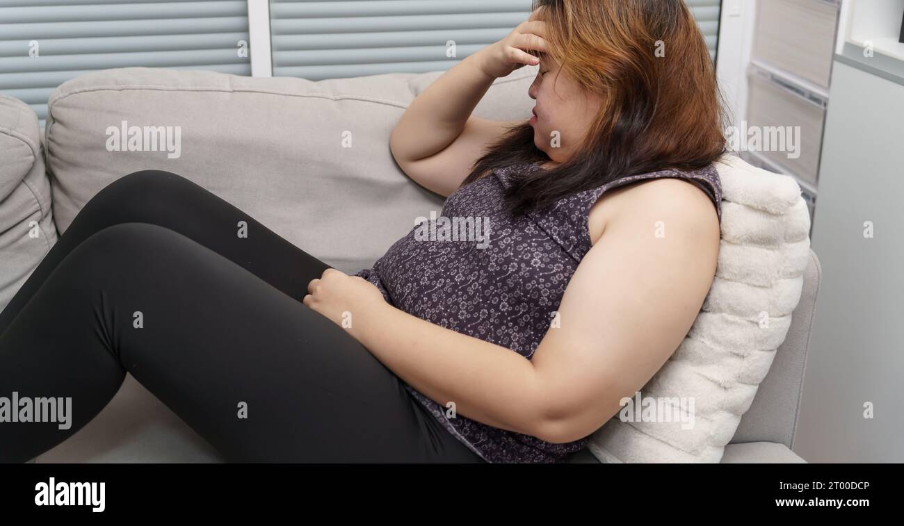 Sad Overweight plus size woman thinking about problems on sofa upset ...