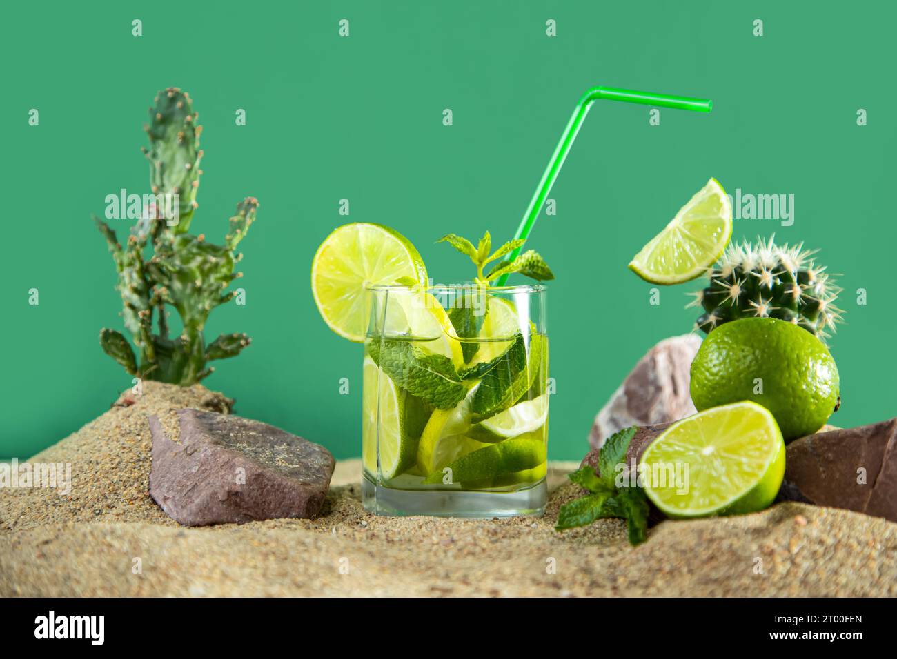 Glass of lemonade with lime and mint among the sand dunes and cacti ...