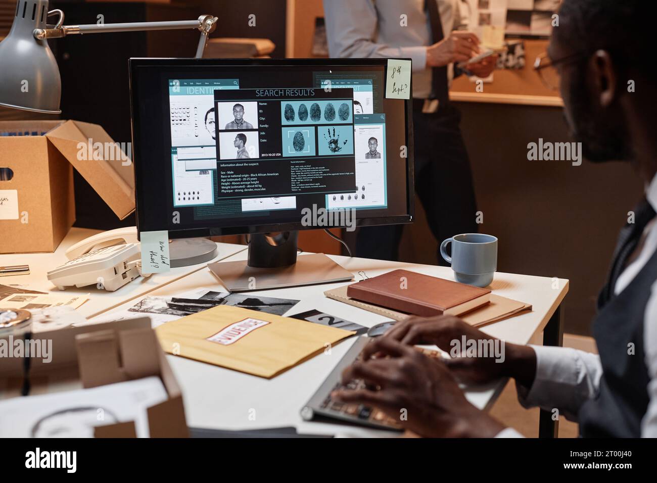 Closeup of male detective using computer at workplace and reading ...