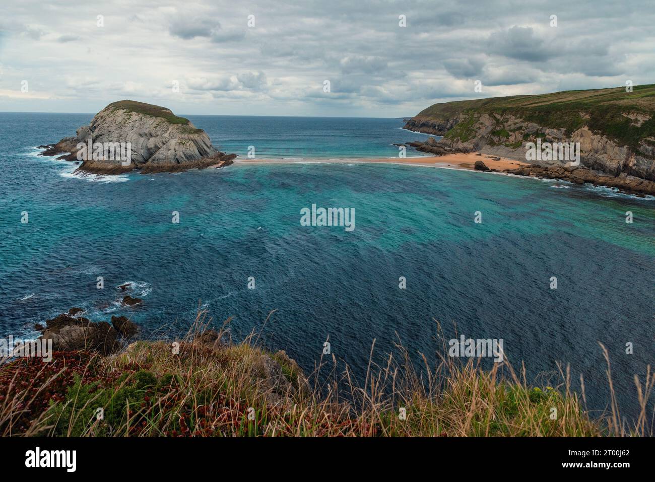 Moody landscape of Isla del Castro with Covachos beach in Santander ...