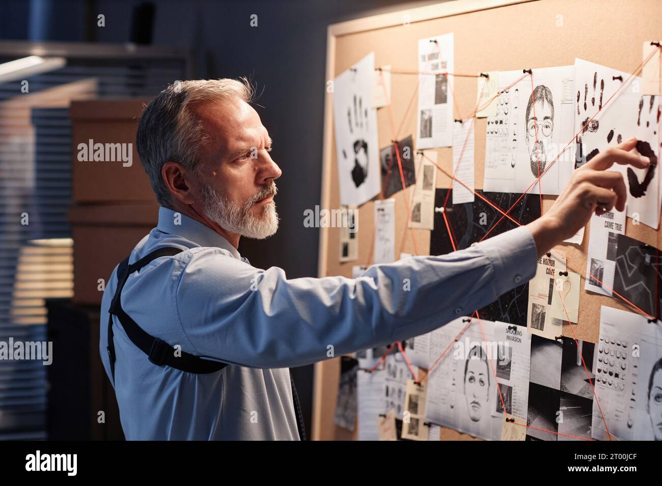 Side view portrait of handsome bearded detective standing by evidence ...