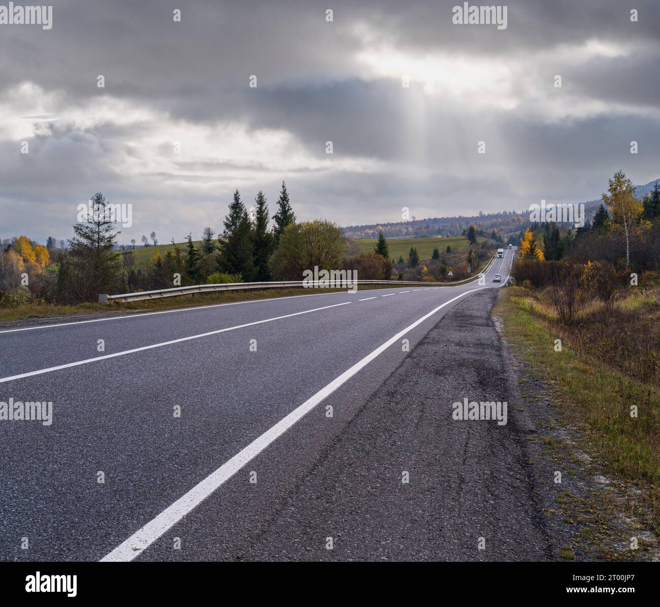 Hazy and overcast Carpathian Mountains and highway on mountain pass ...