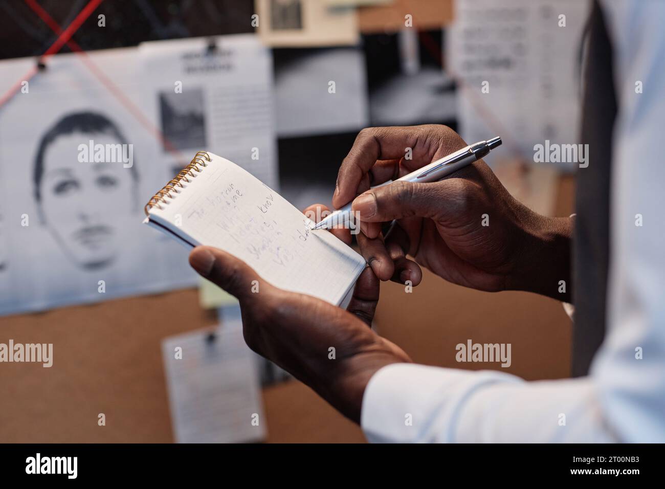 Closeup of detective writing in notebook while investigating case in ...