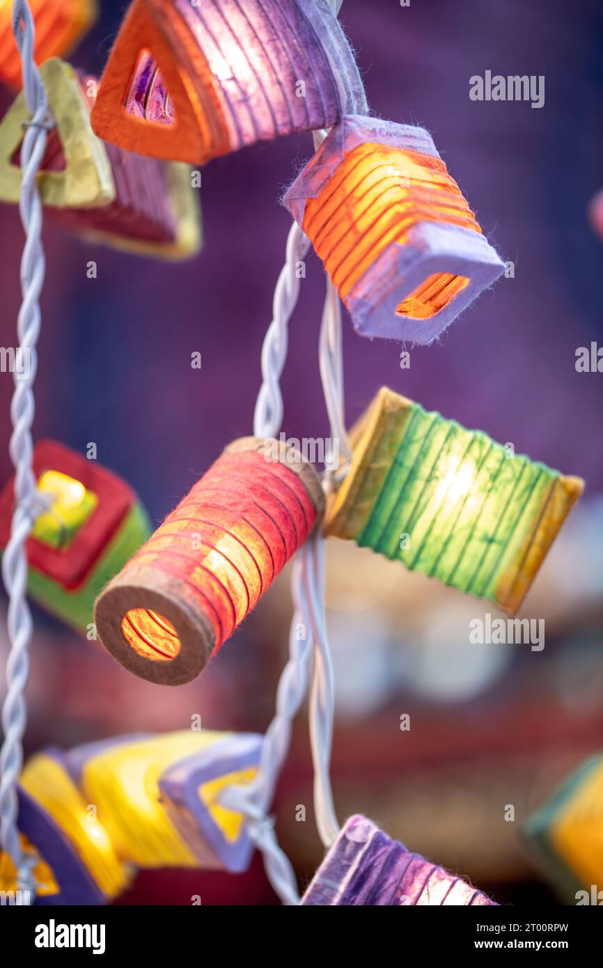 A string of lights with small colorful paper lanterns shining in ...