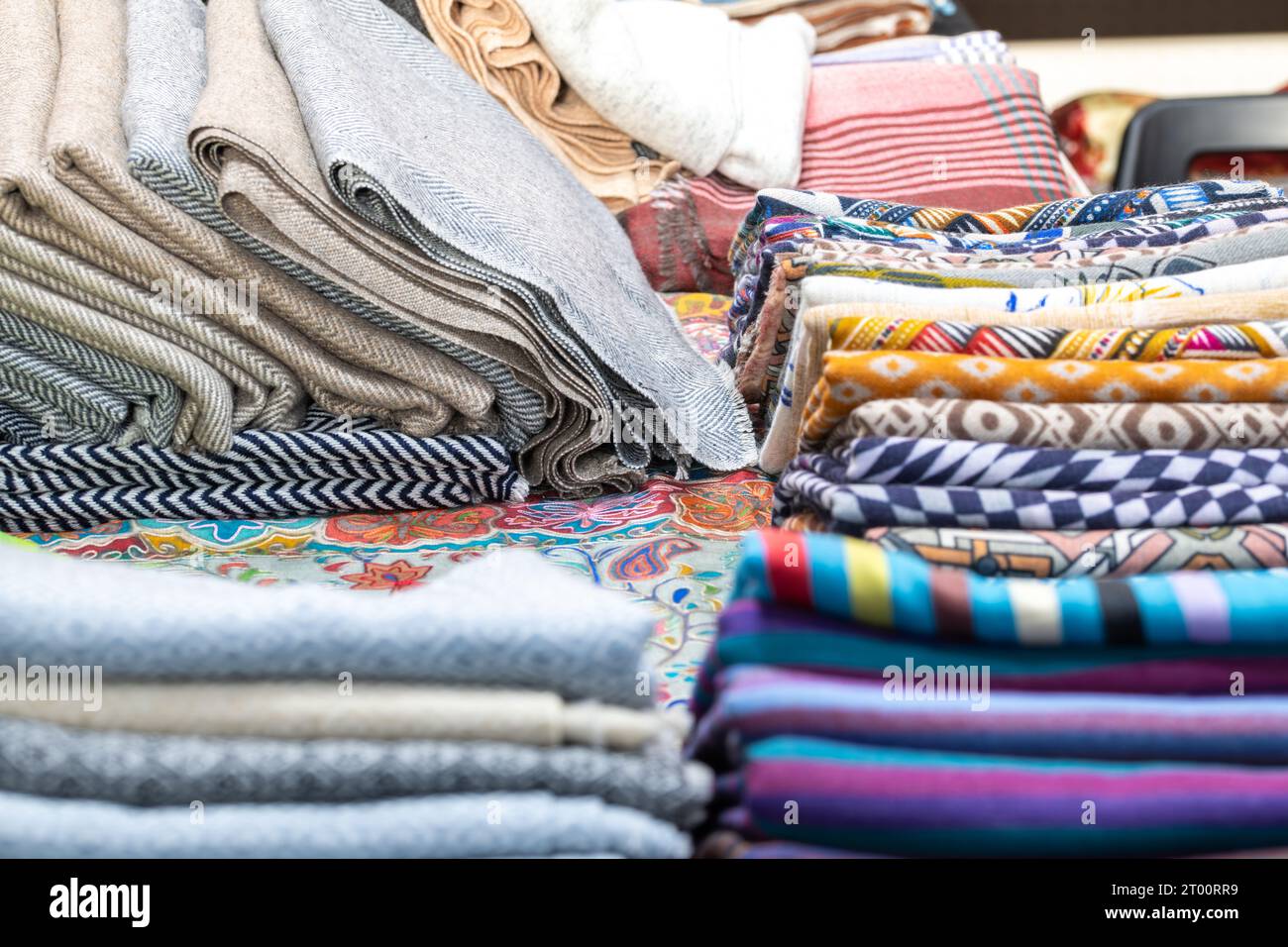Various fabrics folded on a table with different patterns, materials ...