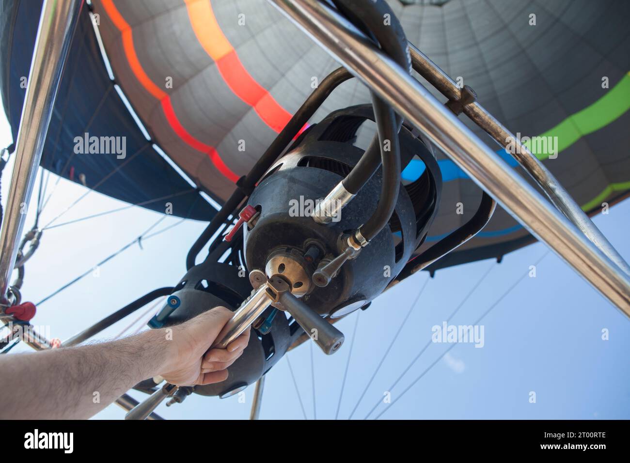 Hot air balloon pilot operating the burners. Low angle inside view ...