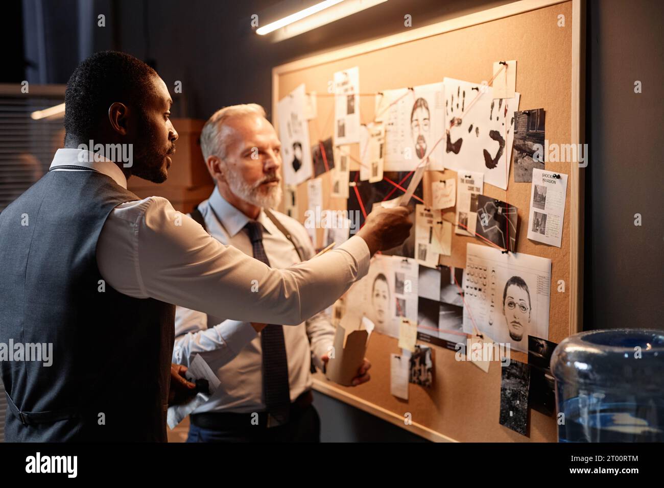 Side view portrait of African American detective pointing at evidence ...