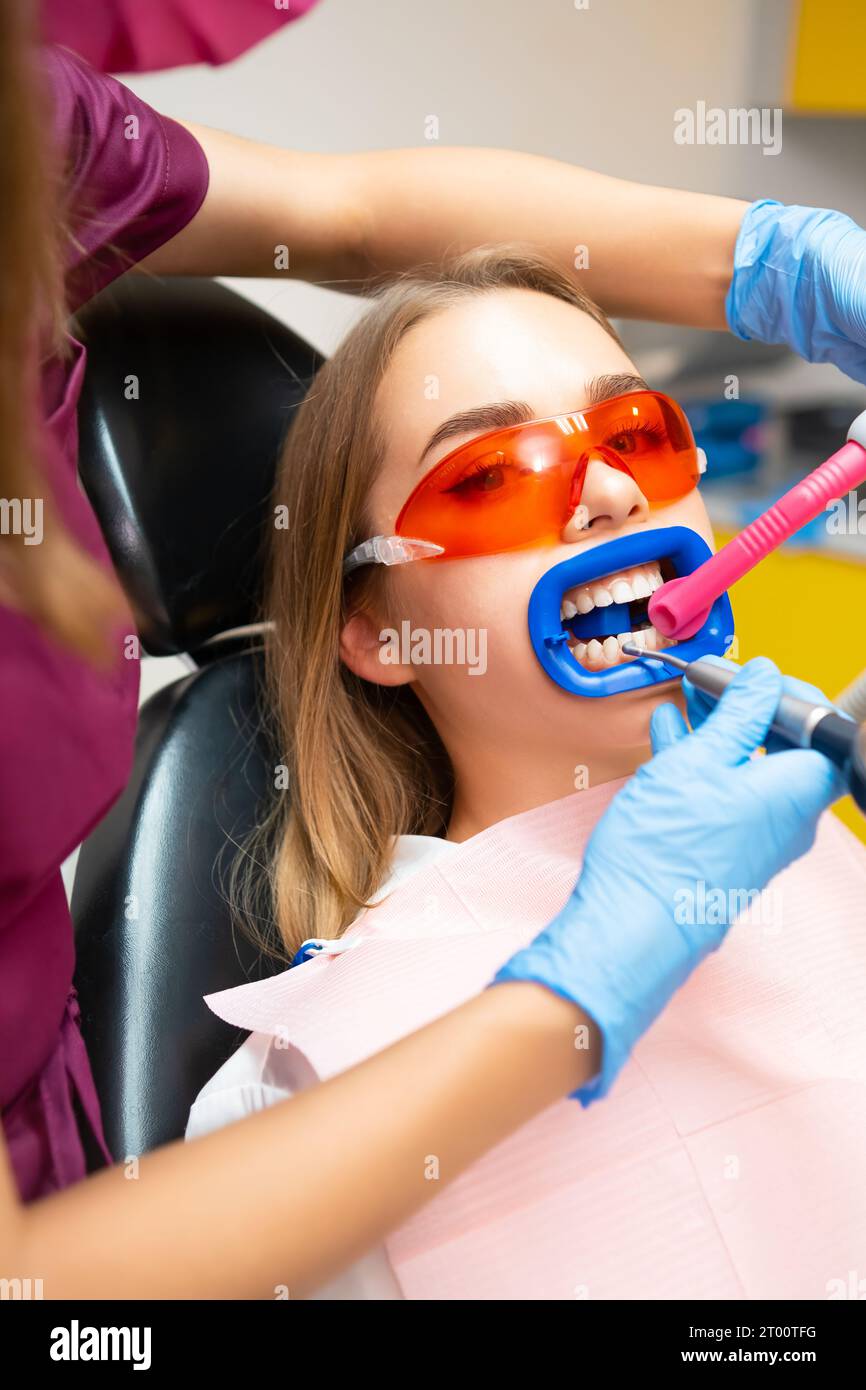 Woman wearing protective goggles from ultraviolet light sits with tube ...