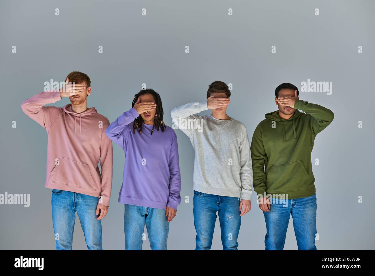 four multiracial friends in casual street wear covering eyes with palms ...