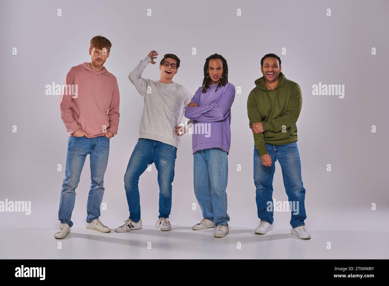 four young multicultural man in casual outfits standing and laughing at ...