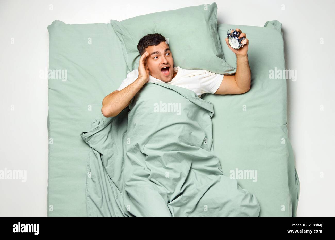 Young attractive confused man lying on his back shouting looking at ...