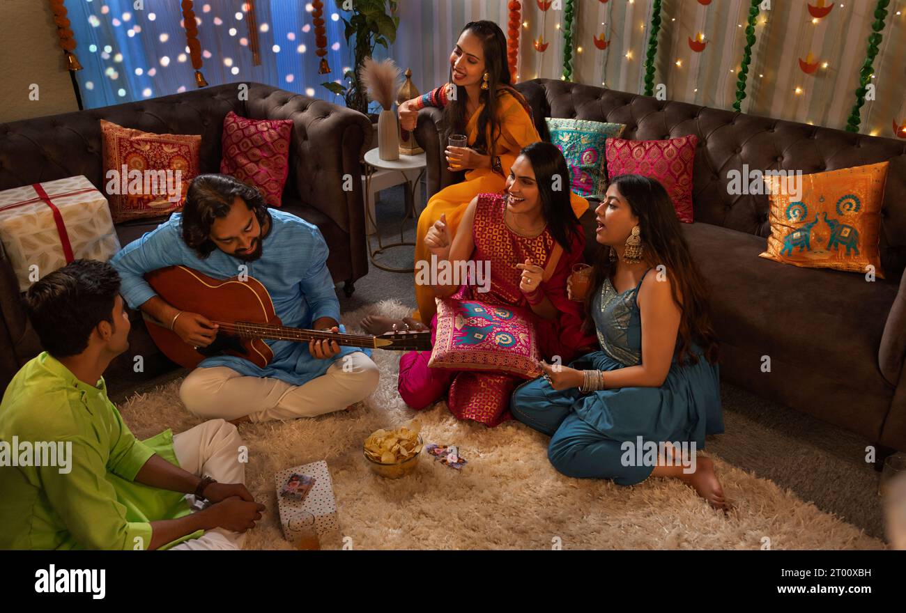 Friends celebrating Diwali together at home by singing Stock Photo - Alamy