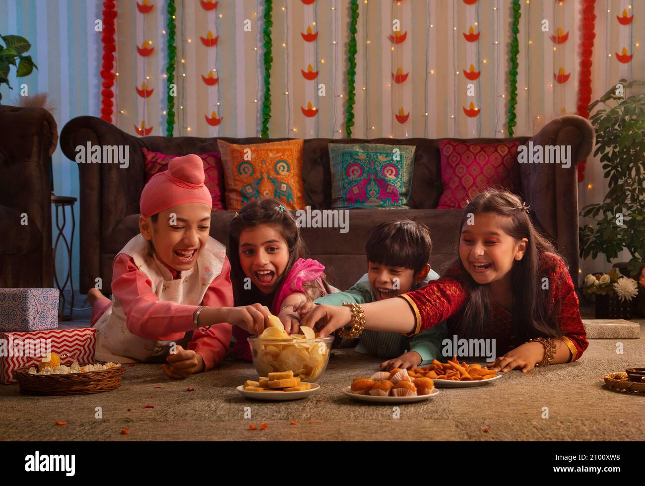 Children lying down on floor and eating potato chips Stock Photo - Alamy