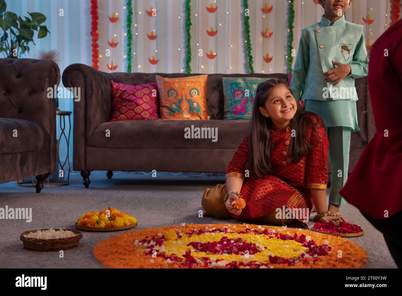 Girl in traditional clothing making floral rangoli on the occasion of ...