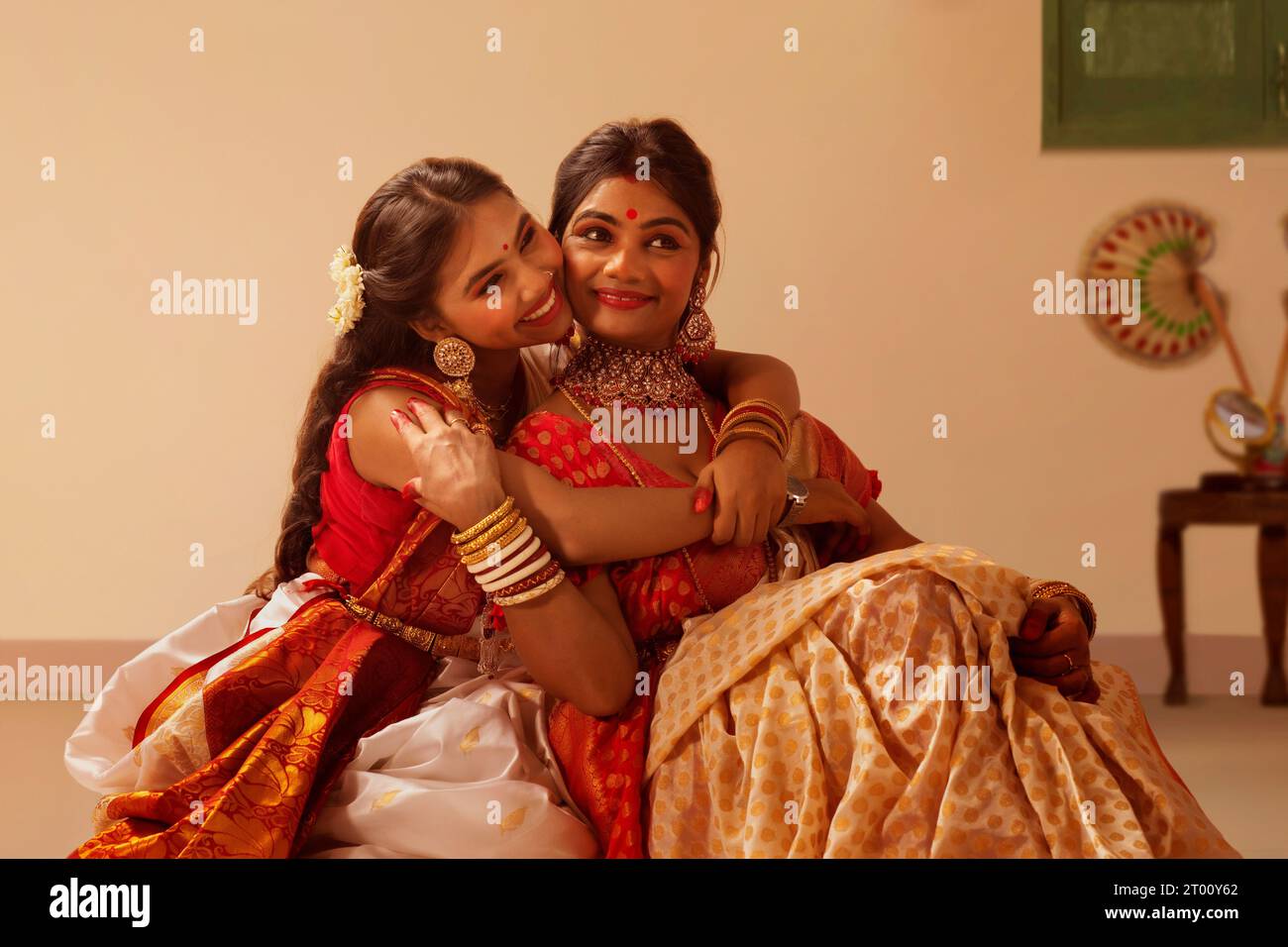 Mother and daughter in traditional outfit embracing each other at home ...