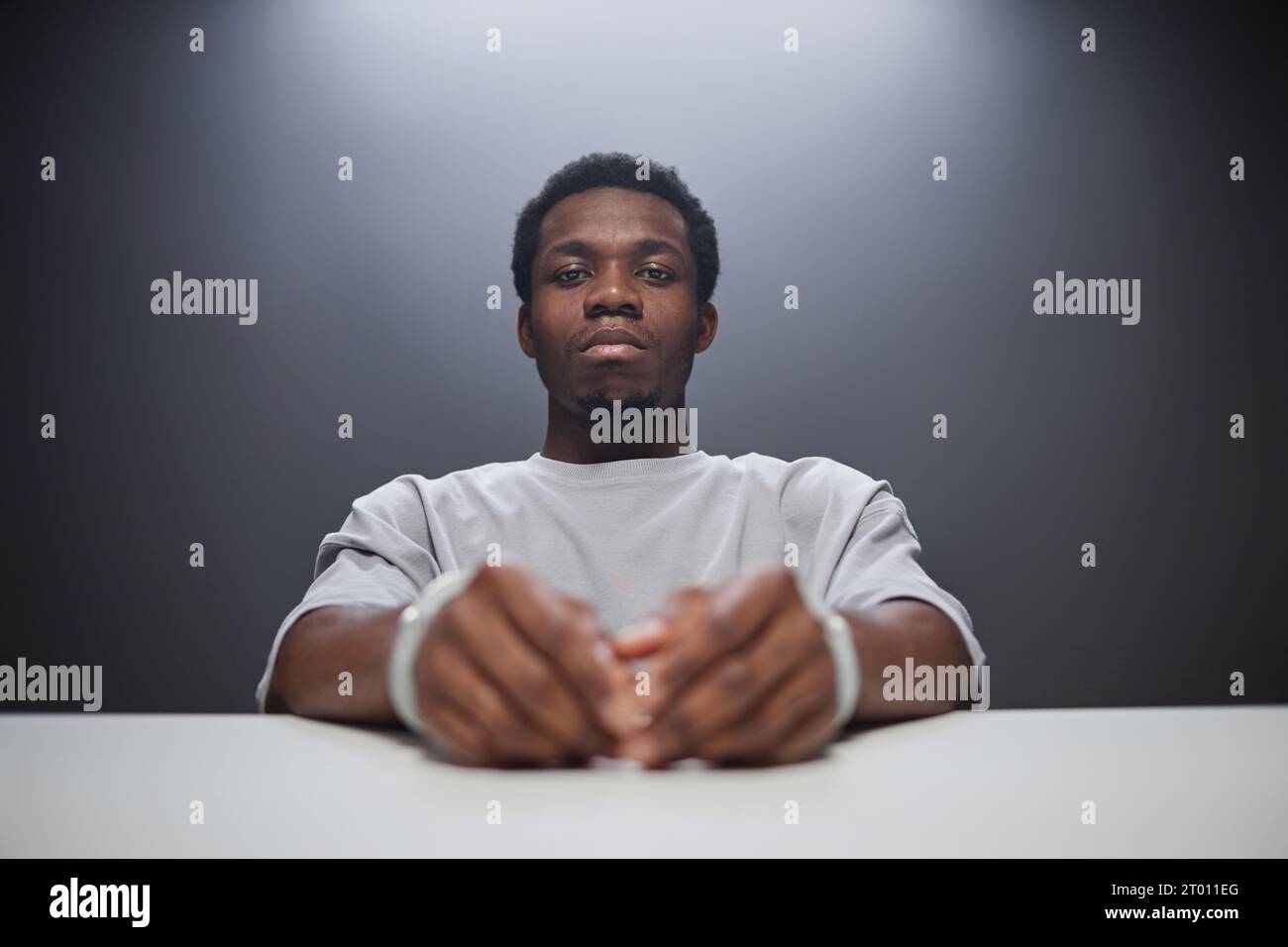 Minimal front view portrait of Black young man wearing handcuffs and ...