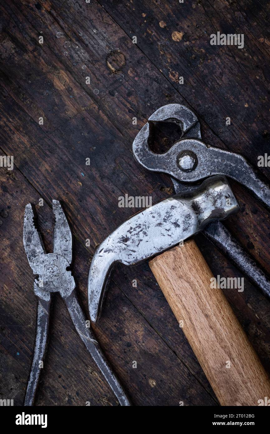 Old pliers, hammer and pincers on an old wooden workbench. Old work ...