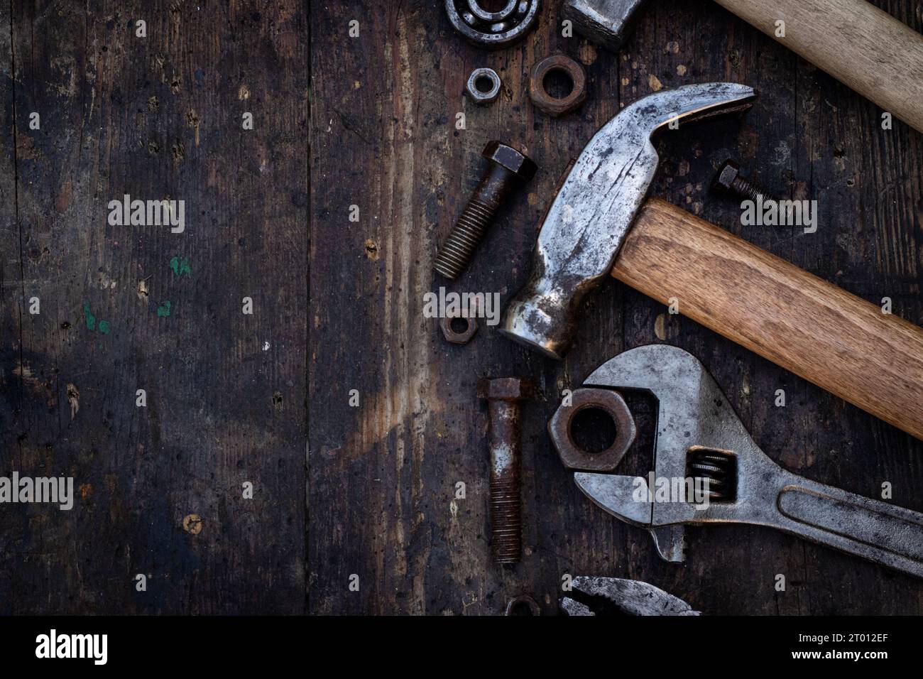 Old work tools nuts, bolts and bearings lie on a wooden workbench Stock ...