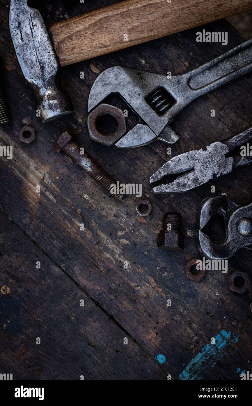 Old work tools nuts, bolts and bearings lie on a wooden workbench Stock ...